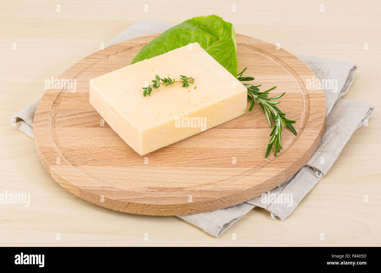 Yellow cheese brick with rosemary and thyme Stock Photo - Alamy