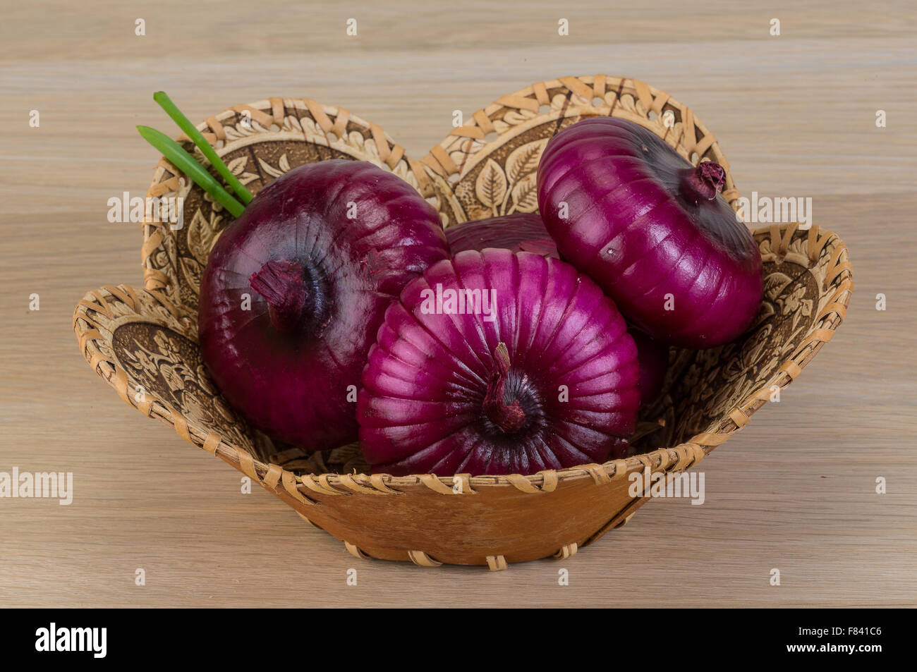 Violet onion in the basket with green Stock Photo - Alamy