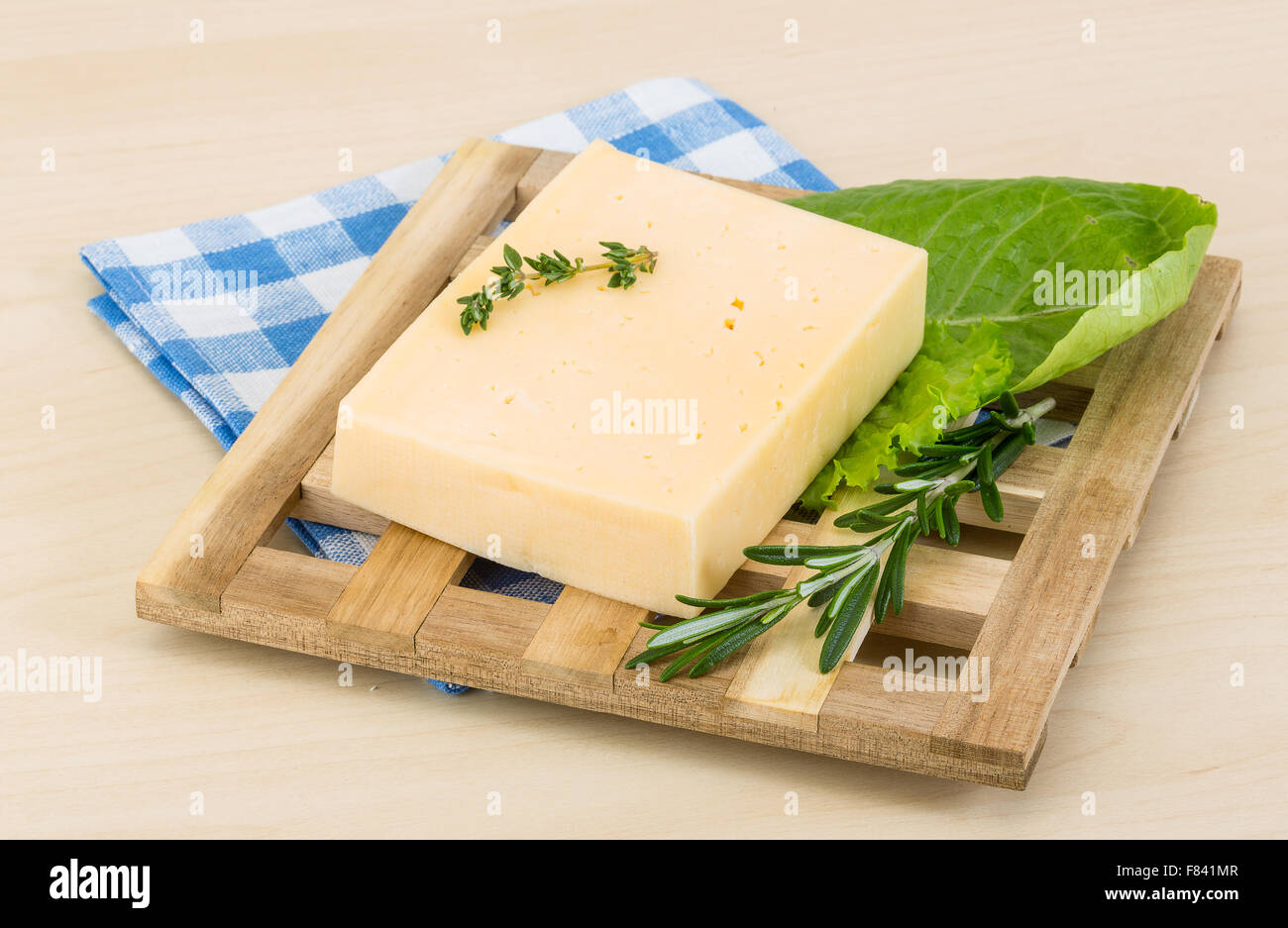 Yellow cheese brick with rosemary and thyme Stock Photo - Alamy