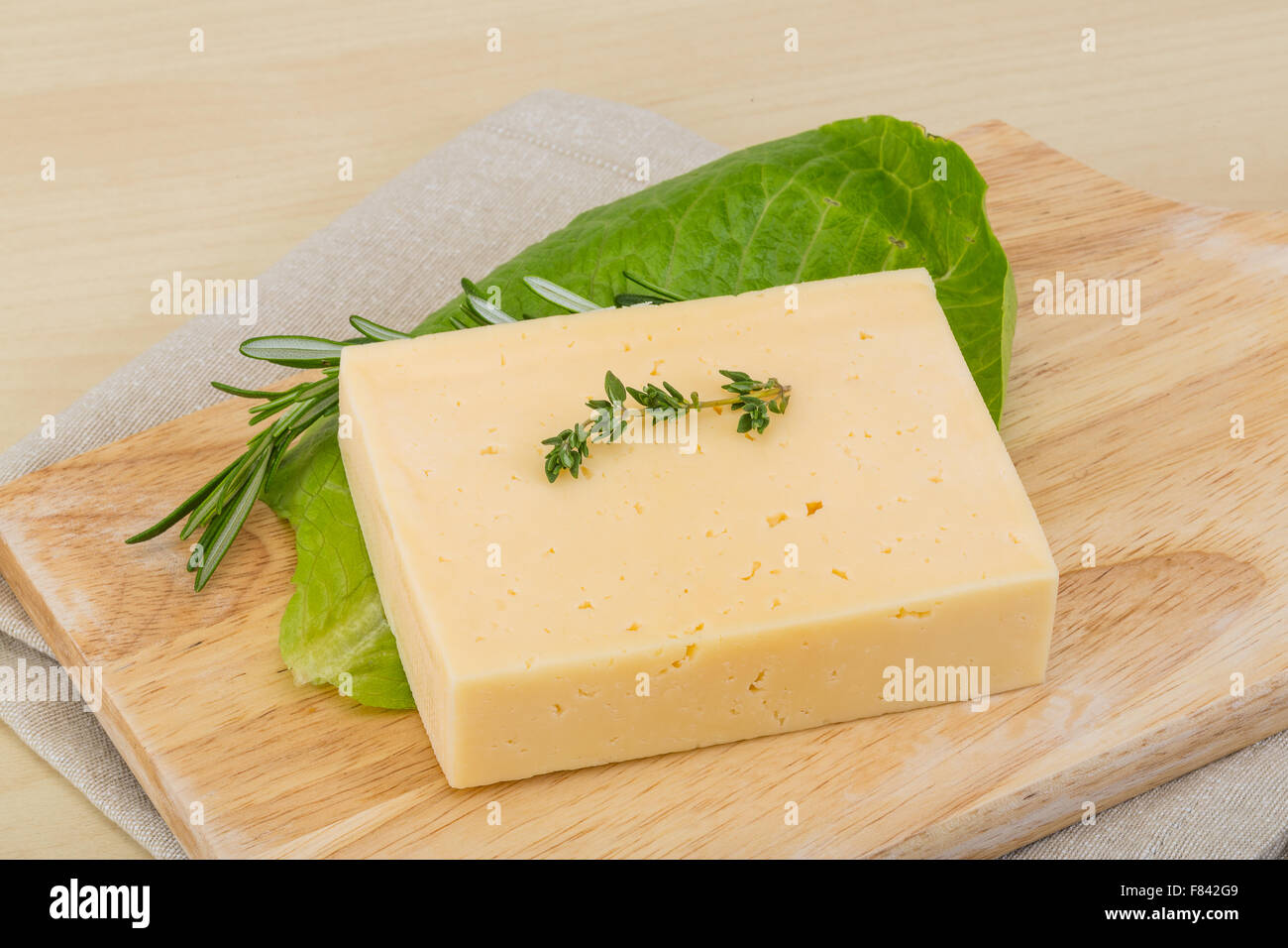 Yellow cheese brick with rosemary and thyme Stock Photo - Alamy