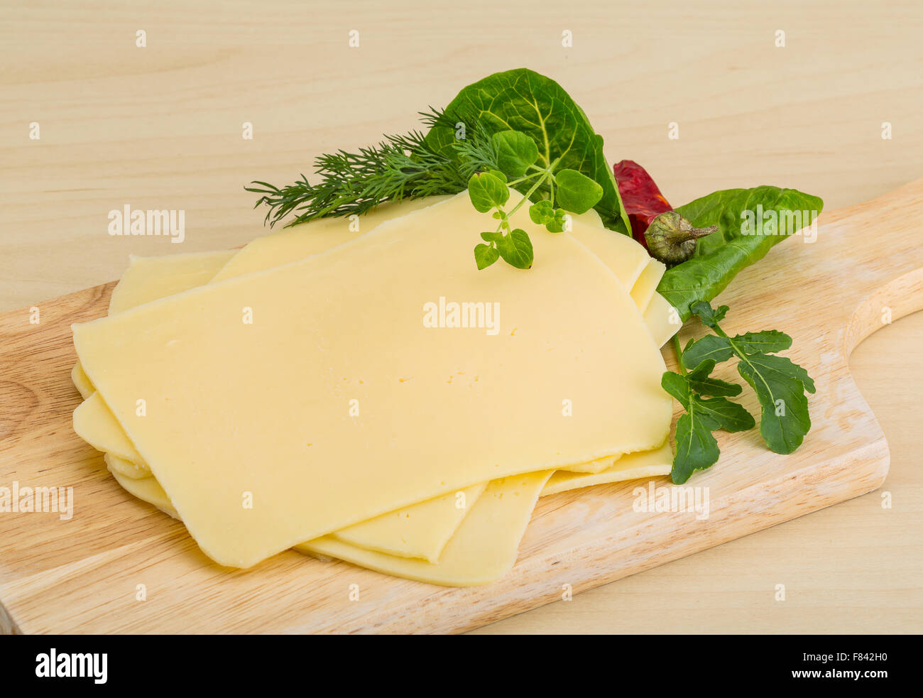 Sliced Cheese with herbs on the wooden bckground Stock Photo - Alamy
