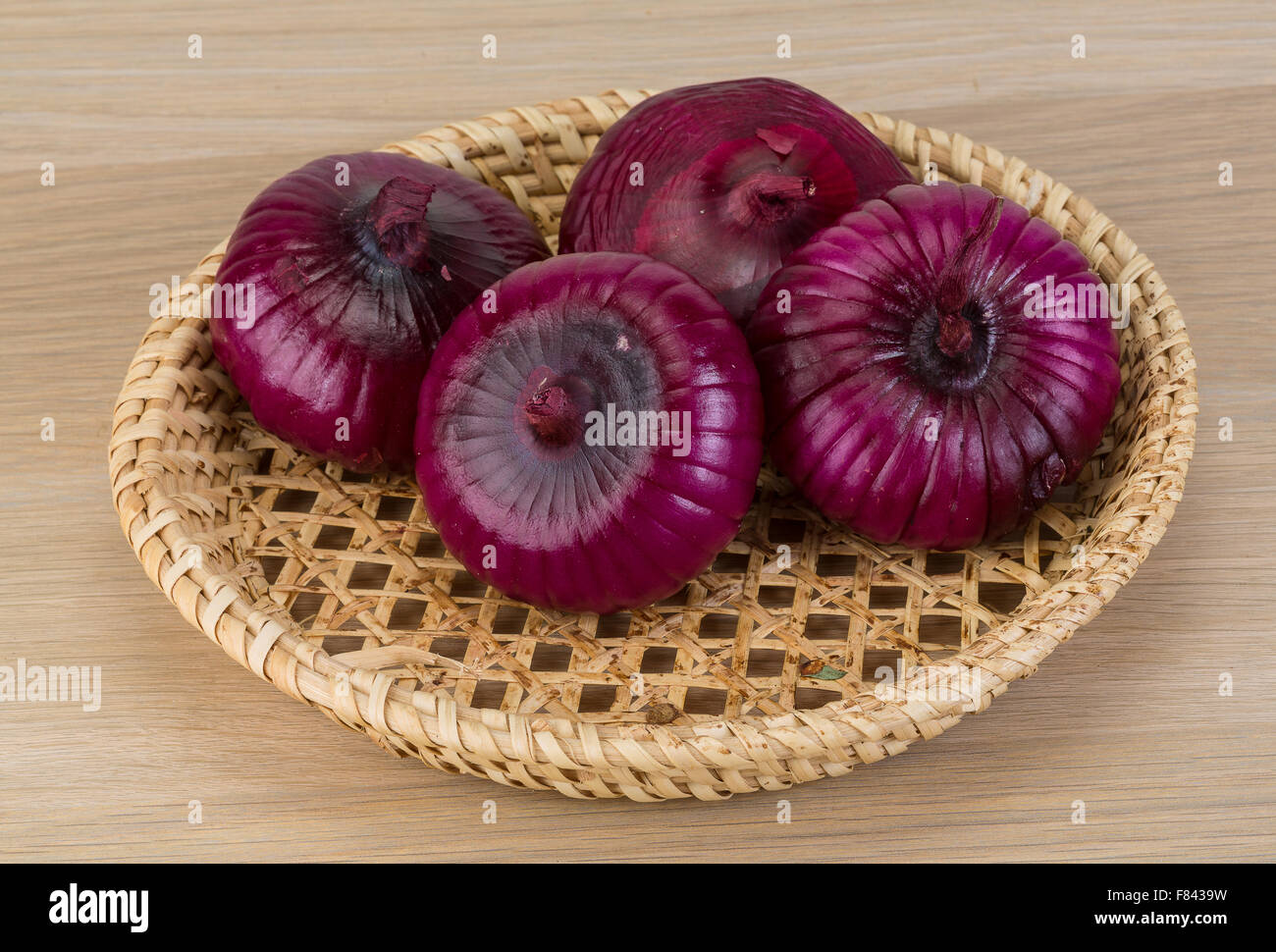 Violet onion in the basket with green Stock Photo - Alamy