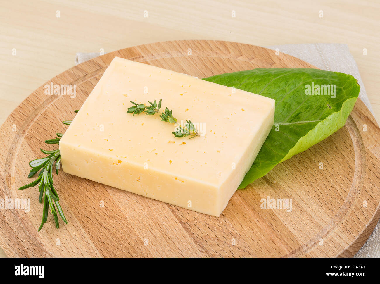 Yellow cheese brick with rosemary and thyme Stock Photo - Alamy
