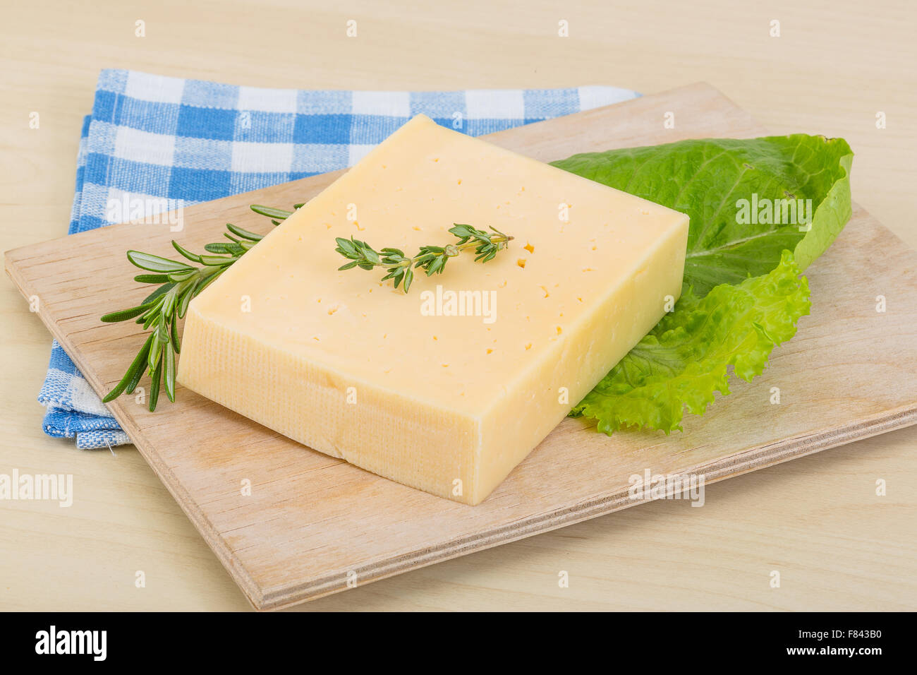 Yellow cheese brick with rosemary and thyme Stock Photo - Alamy