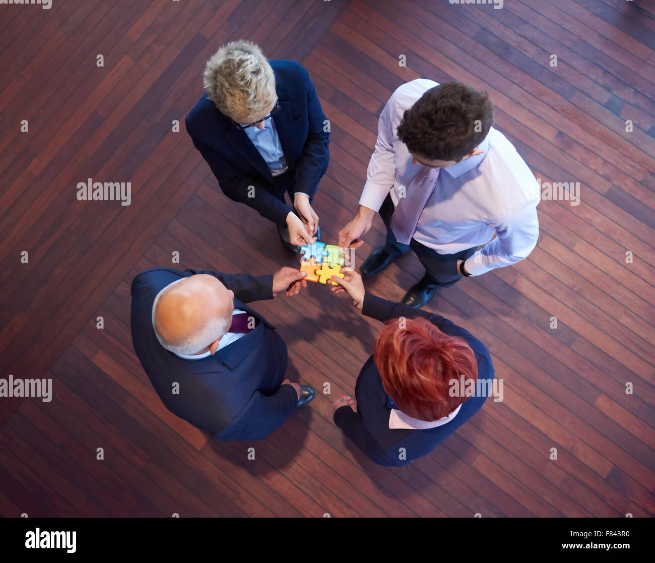 business people group assembling jigsaw puzzle and represent team ...