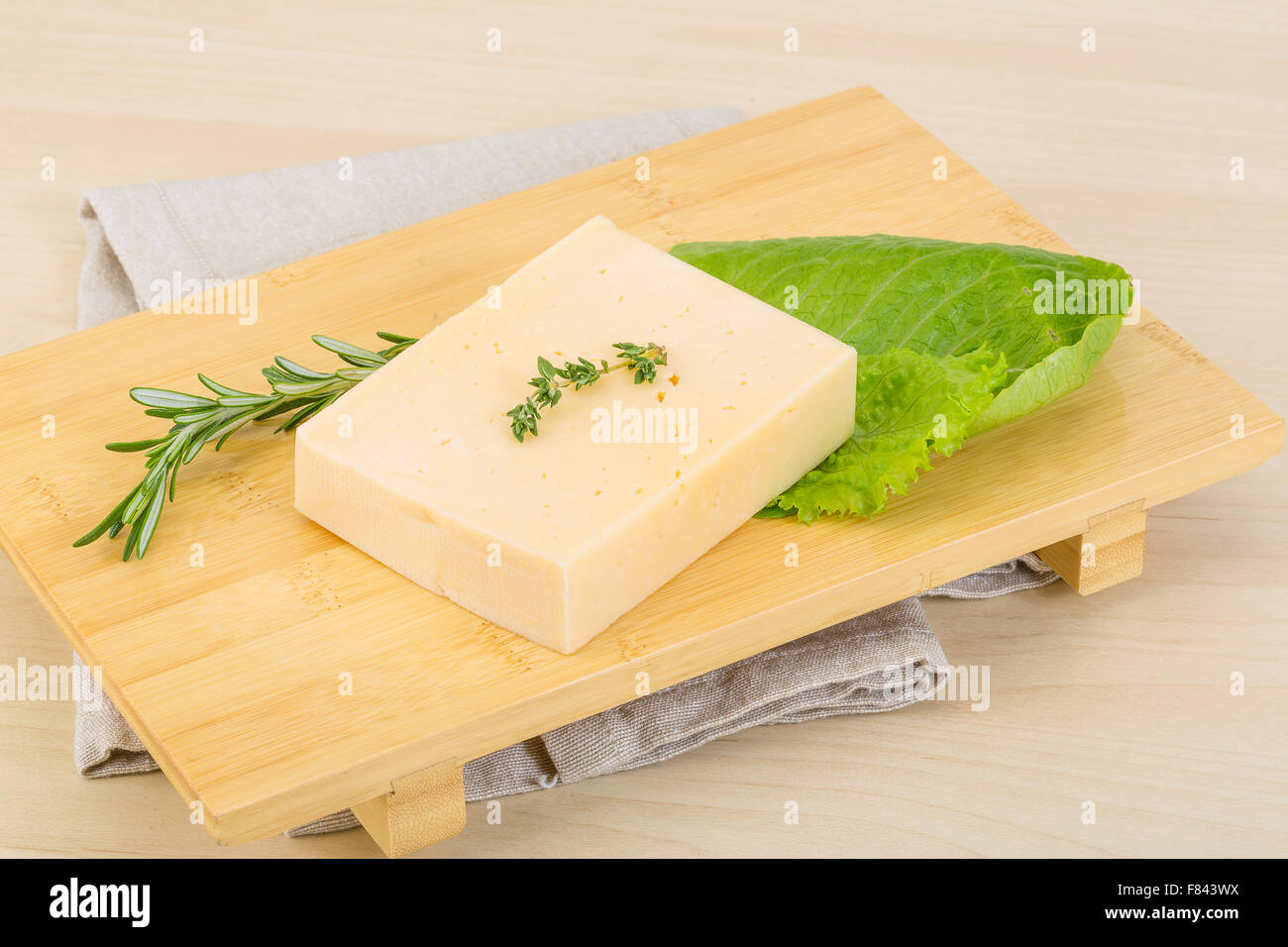 Yellow cheese brick with rosemary and thyme Stock Photo - Alamy