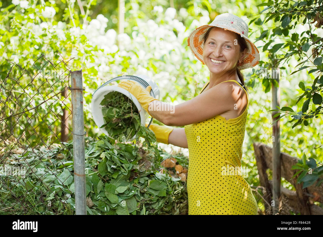 Female farmer making compost in garden Stock Photo - Alamy