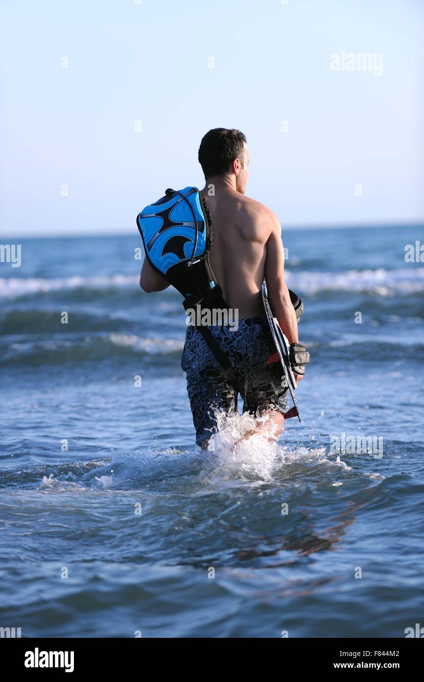 Portrait of a strong young surf man at beach on sunset in a ...