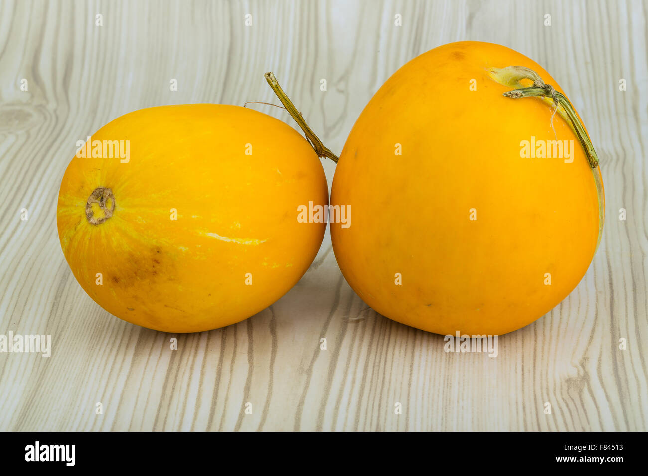 Small yellow melon on the wooden background Stock Photo - Alamy