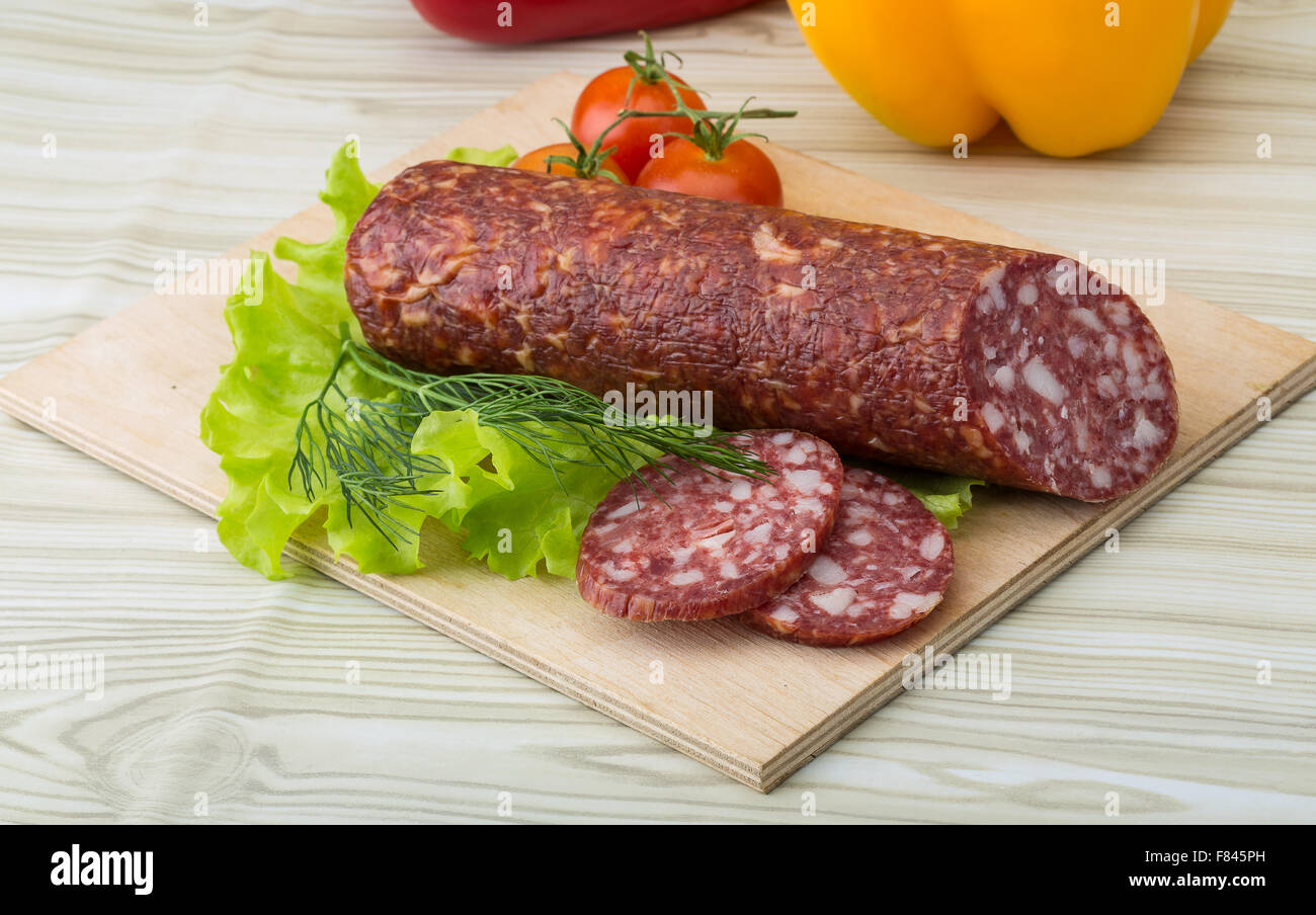 Sliced Salami with salad leaves on the wood background Stock Photo - Alamy