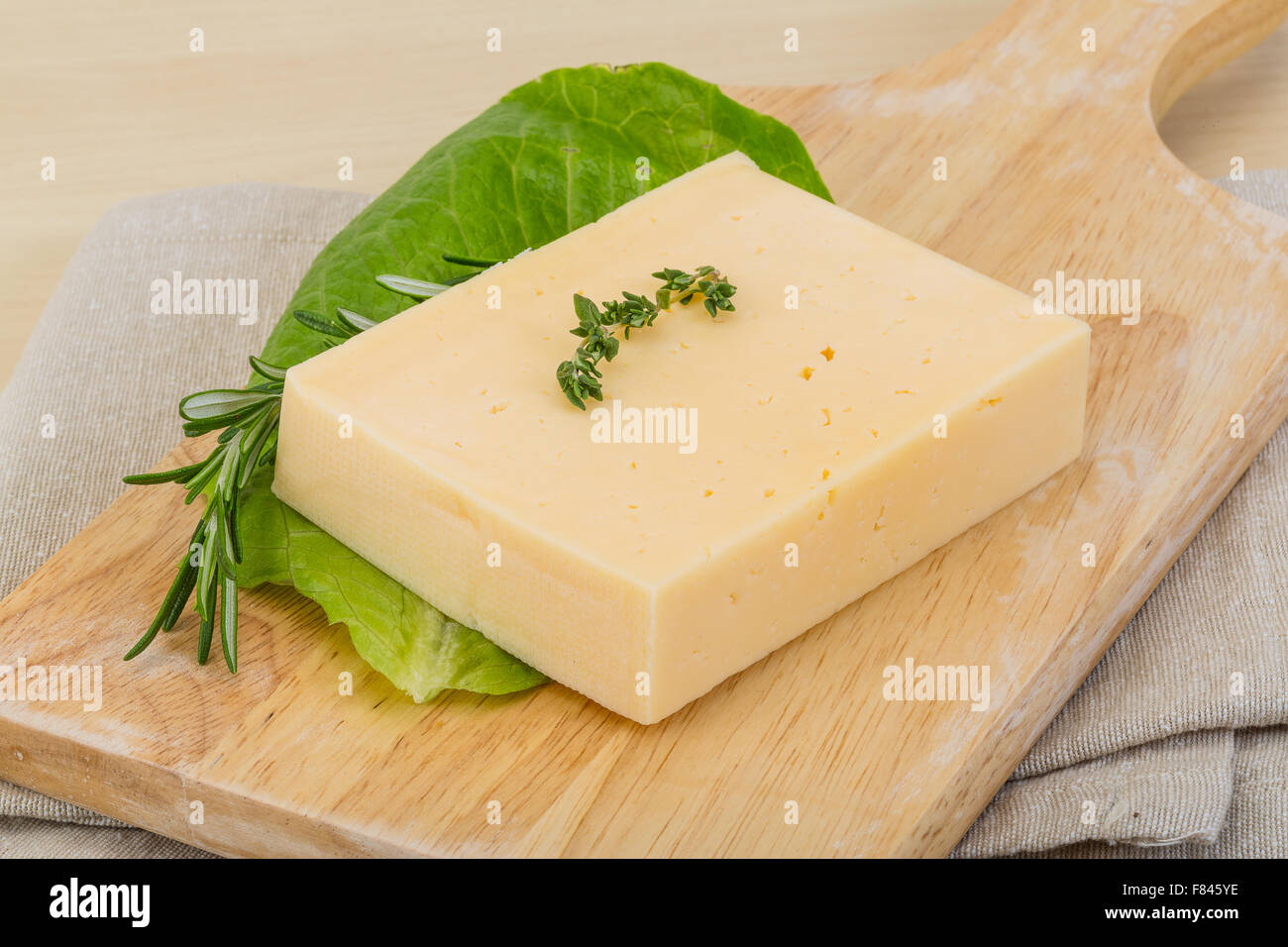 Yellow cheese brick with rosemary and thyme Stock Photo - Alamy