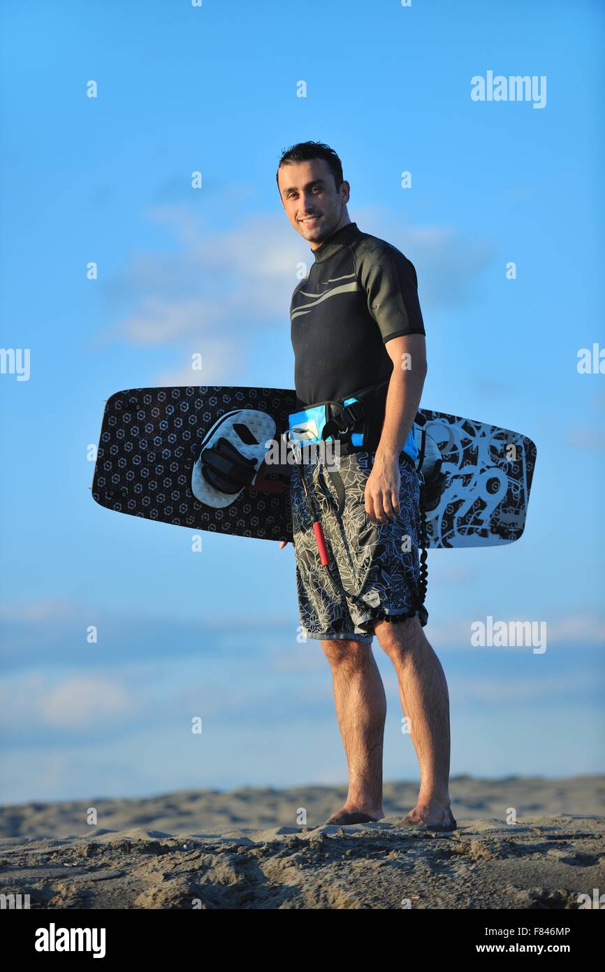 Portrait of a strong young surf man at beach on sunset in a ...