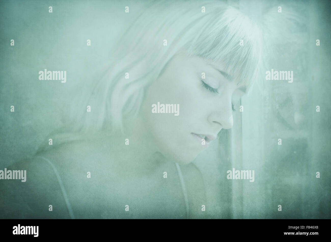 Sad woman leaning against the window Stock Photo - Alamy