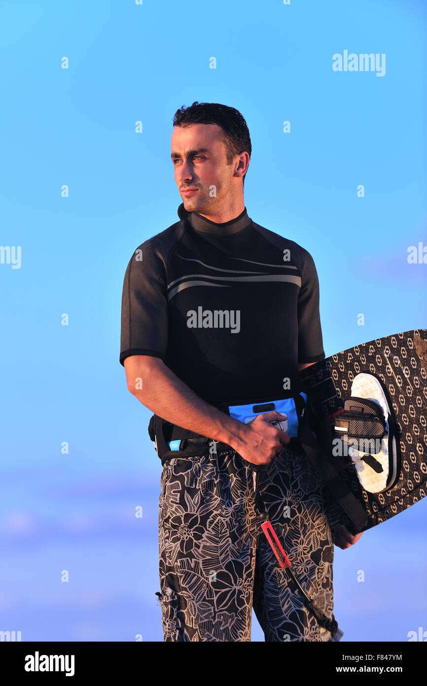 Portrait of a strong young surf man at beach on sunset in a ...