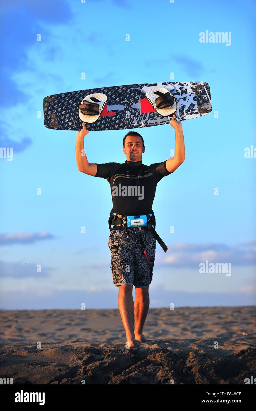 Portrait of a strong young surf man at beach on sunset in a ...