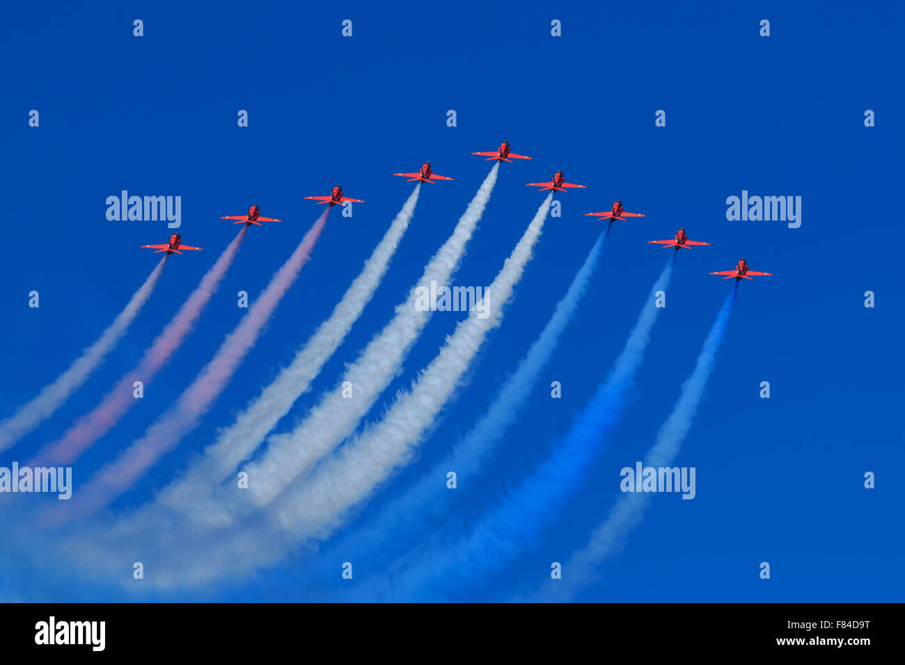 The Red Arrows climbing into a deep blue sky with smoke trails Stock ...