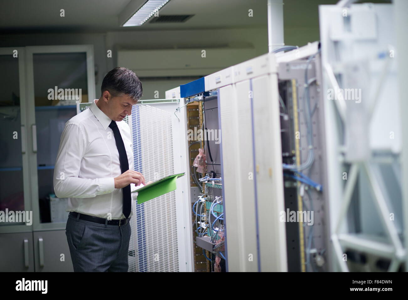 network engineer working in server room, corporate business man working ...