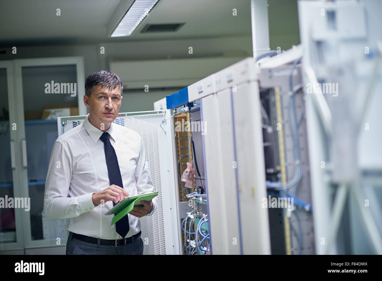 network engineer working in server room, corporate business man working ...