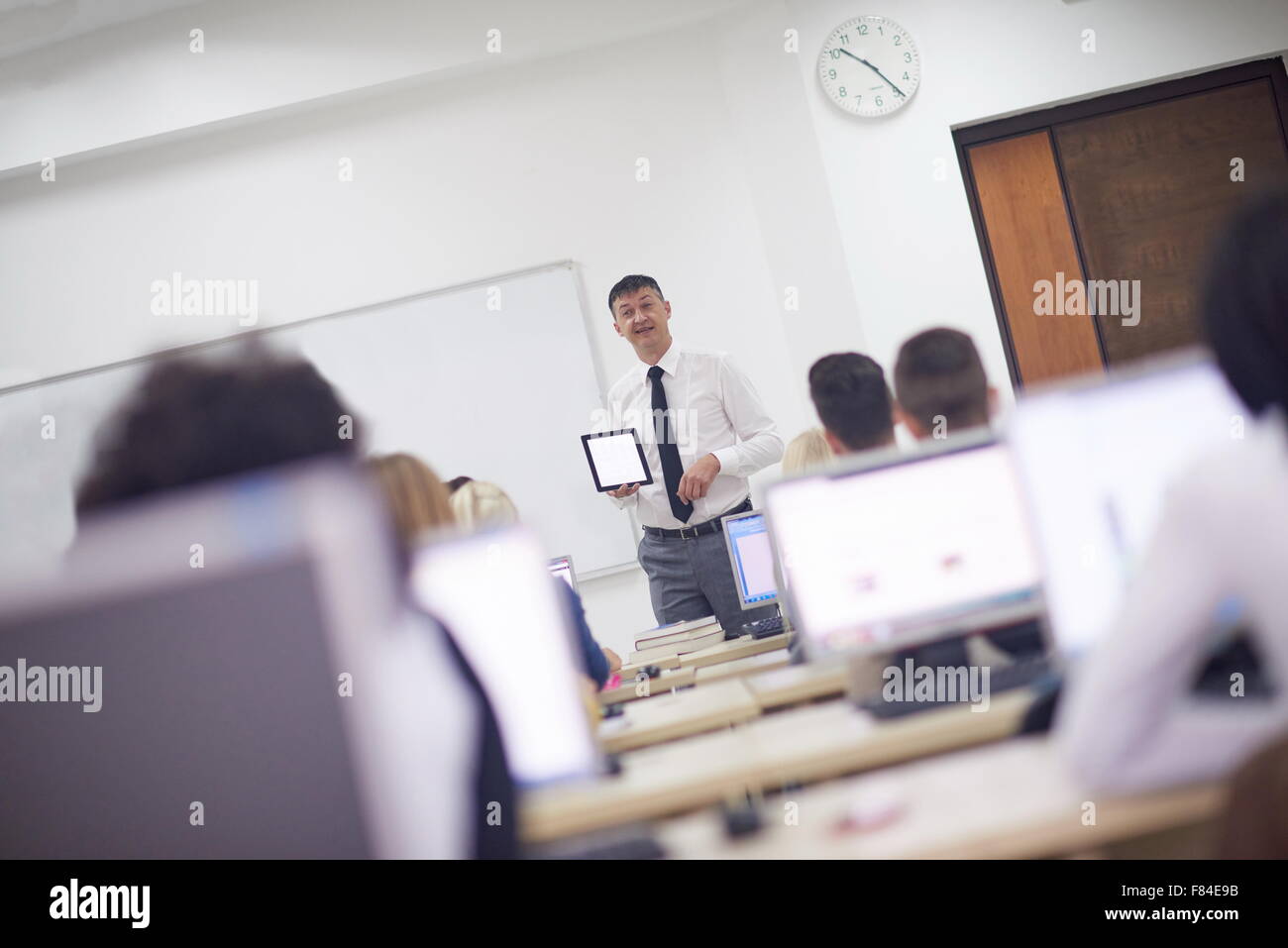 group of students with teacher in computer lab classrom learrning ...