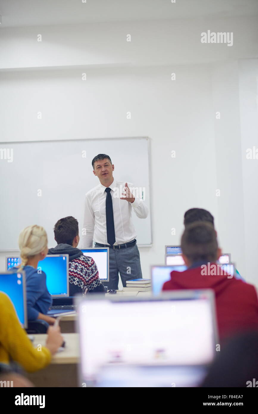 group of students with teacher in computer lab classrom learrning ...