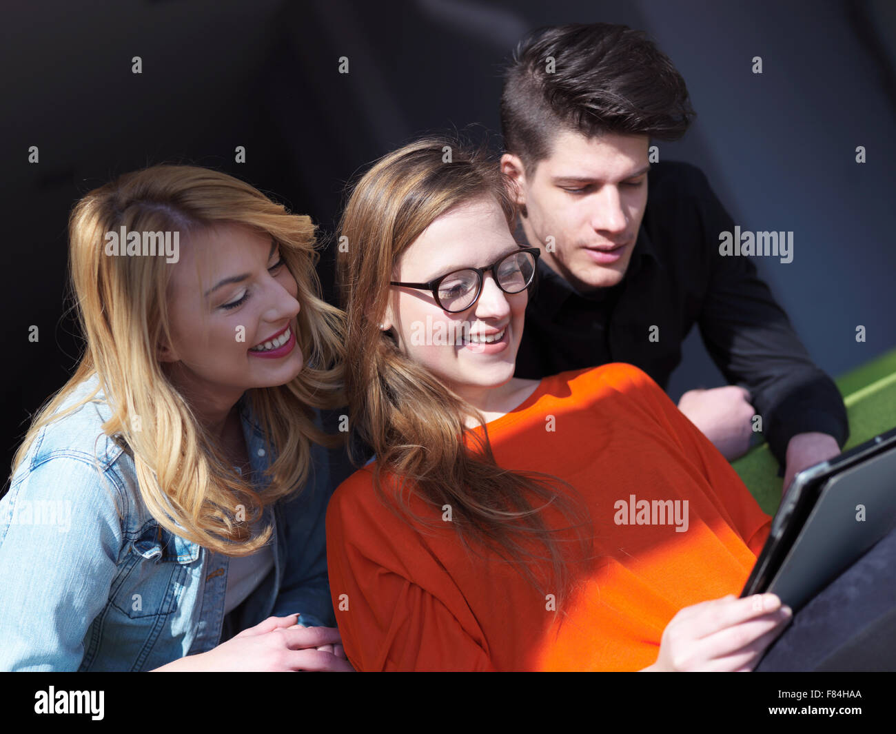 students group working on school project together on tablet computer at ...