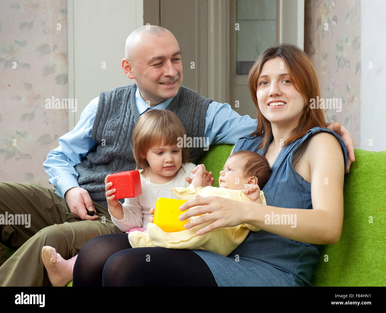 Happy parents with their two kids at home Stock Photo - Alamy