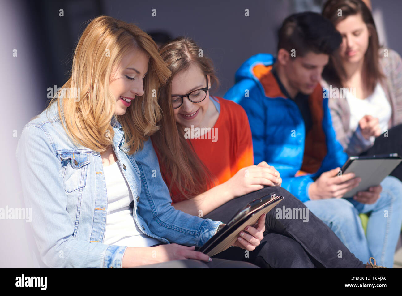 students group working on school project together on tablet computer at ...