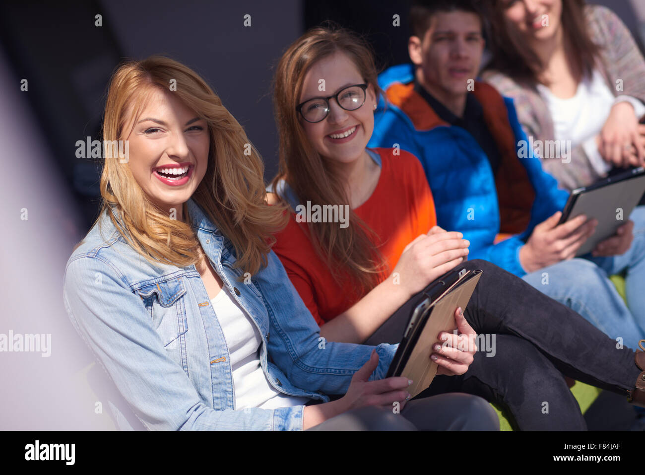 students group working on school project together on tablet computer at ...