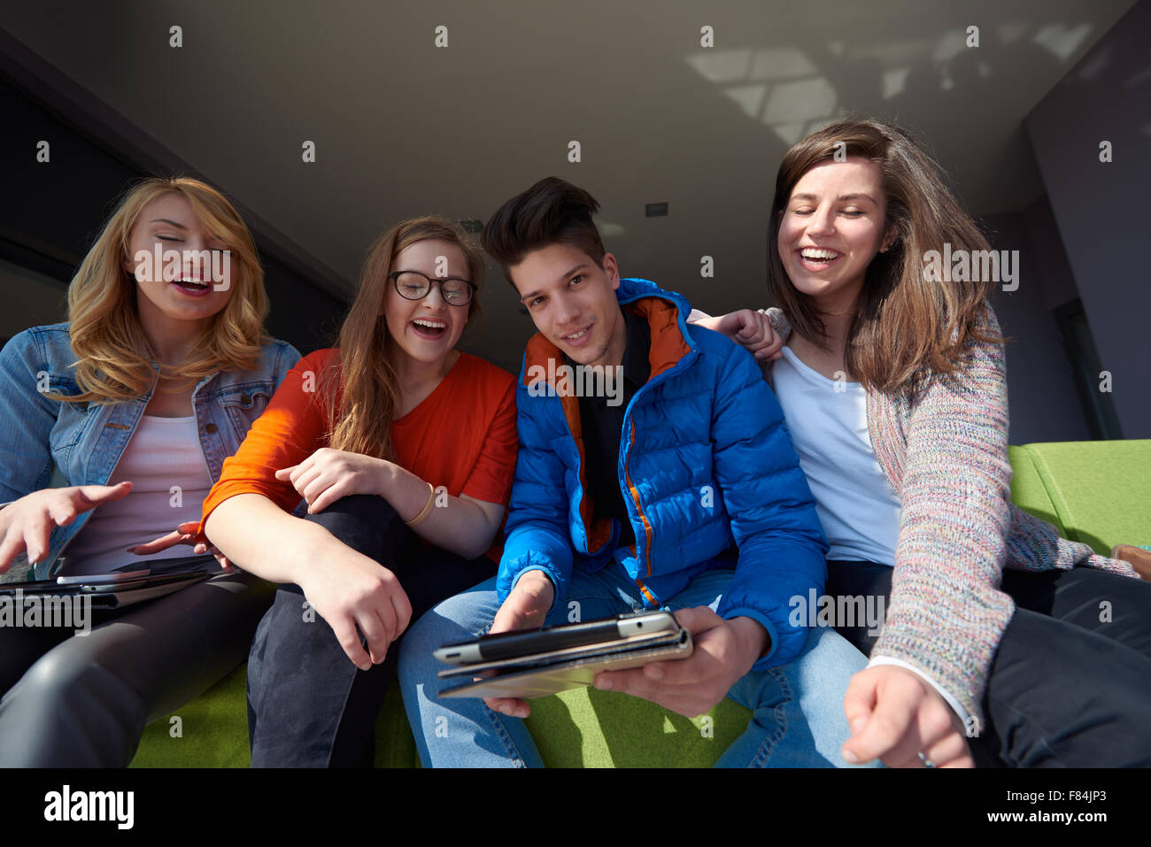 students group working on school project together on tablet computer at ...