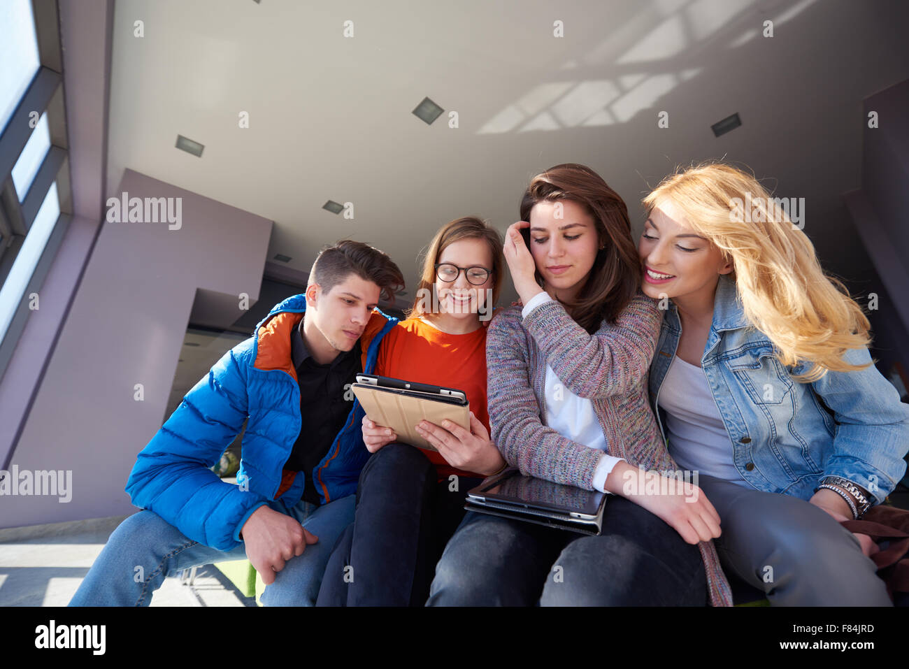 students group working on school project together on tablet computer at ...
