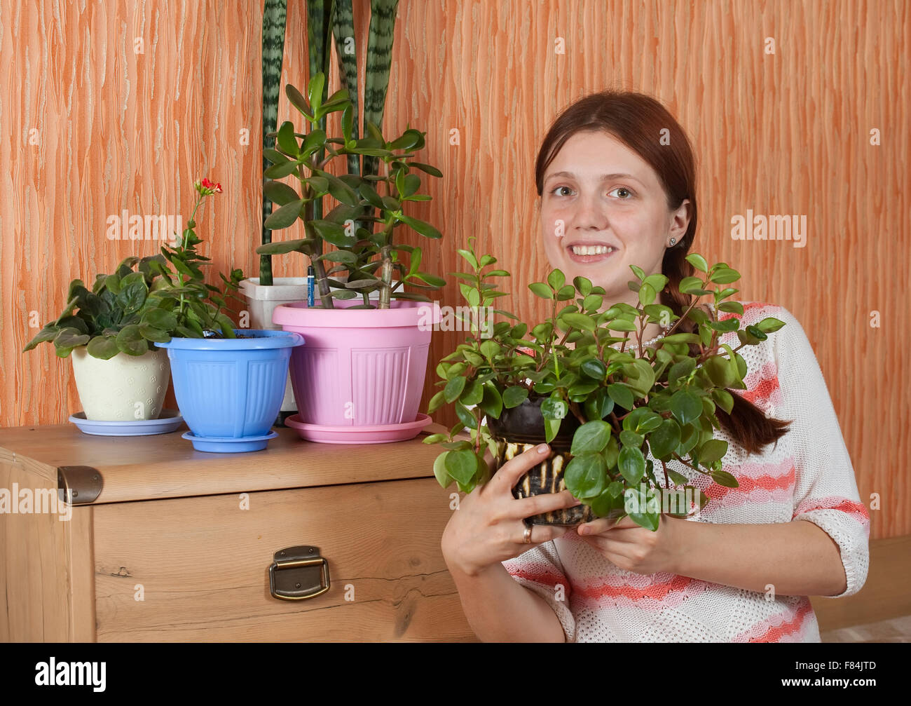 Attractive woman with flowers in the pot at her home Stock Photo - Alamy