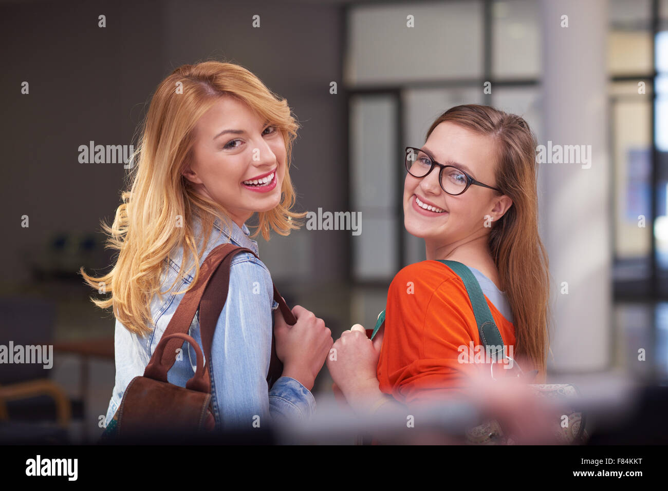 friends together at school, two student girls with backpack and tablet ...