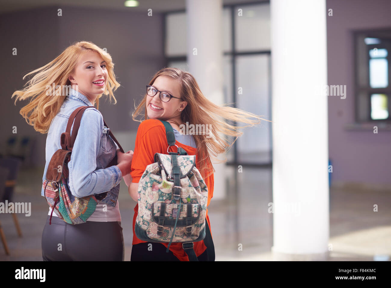 friends together at school, two student girls with backpack and tablet ...