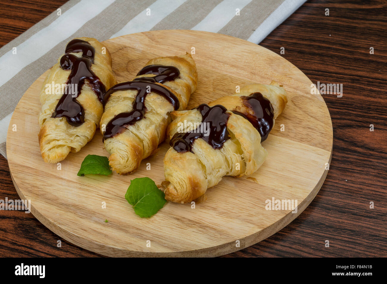 Croissant with chocolate and mint leaves on the wood background Stock ...