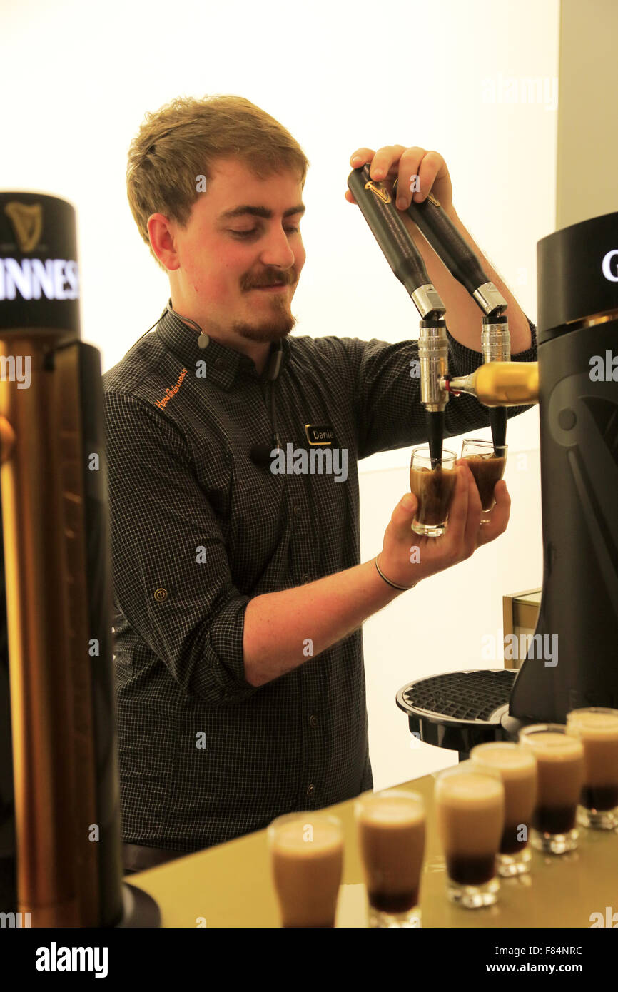 A bartender pouring Guinness beer into testing glasses in Guinness ...