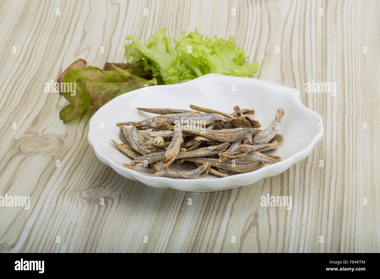 Dries anchovy - small fishes in the bowl Stock Photo - Alamy