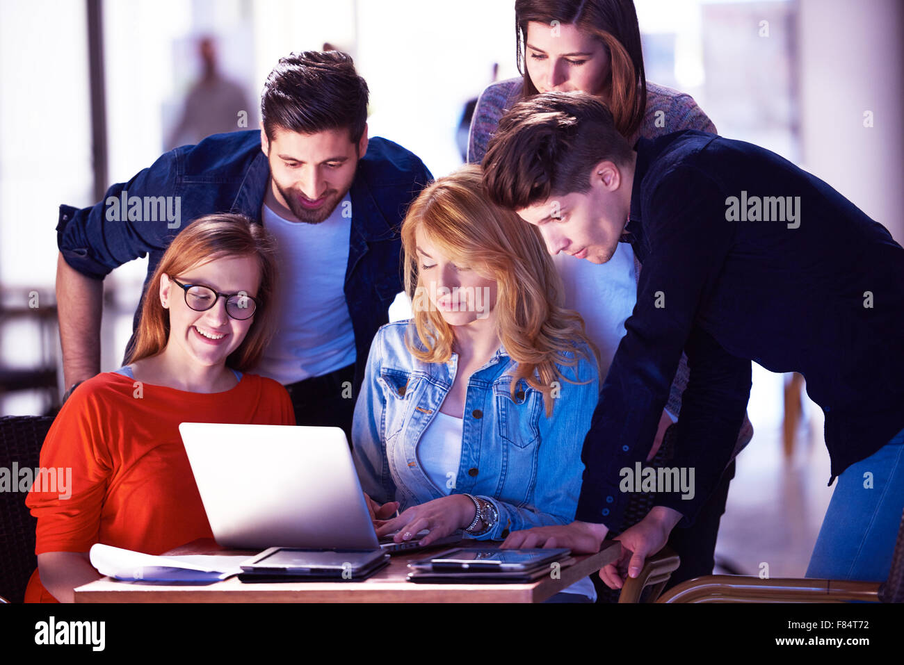students group working on school project together on tablet computer at ...
