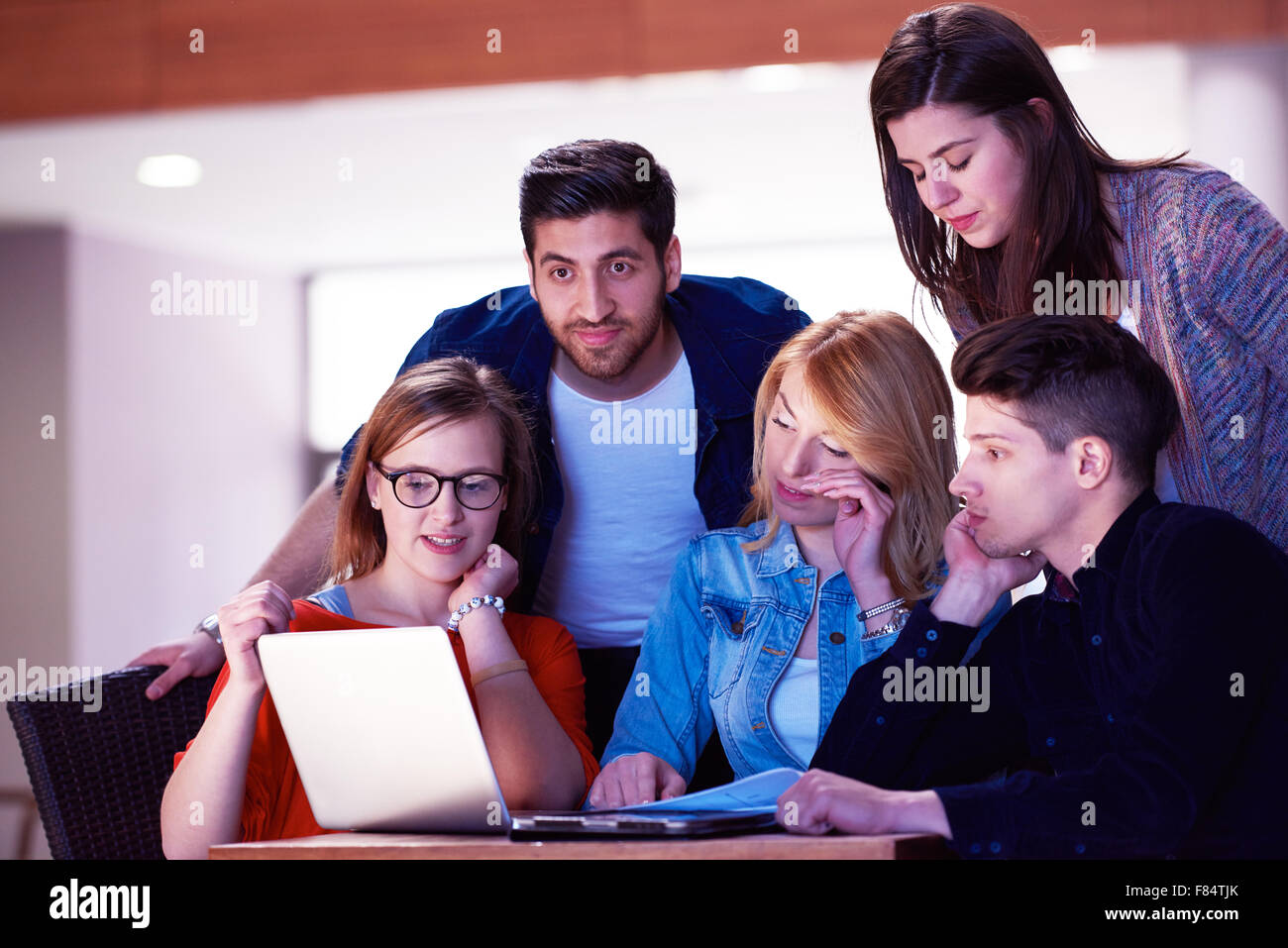 students group working on school project together on tablet computer at ...