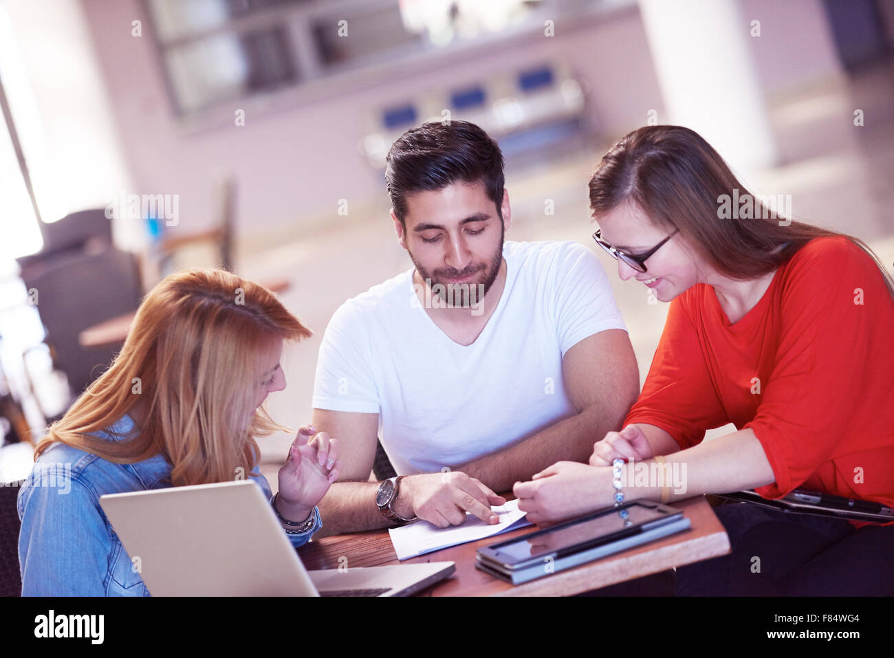 students group working on school project together on tablet computer at ...