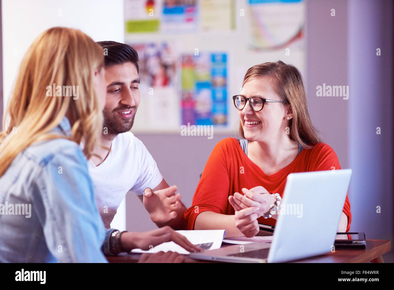students group working on school project together on tablet computer at ...