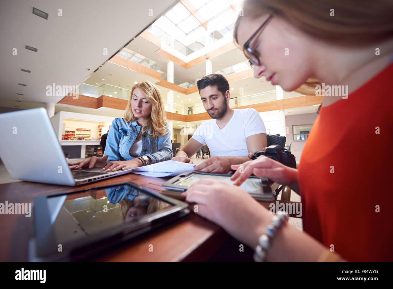 students group working on school project together on tablet computer at ...