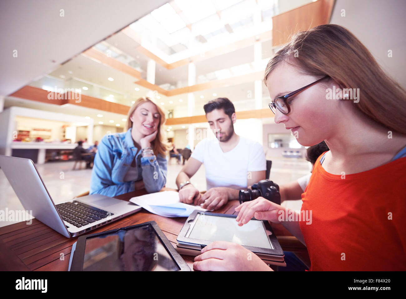 students group working on school project together on tablet computer at ...