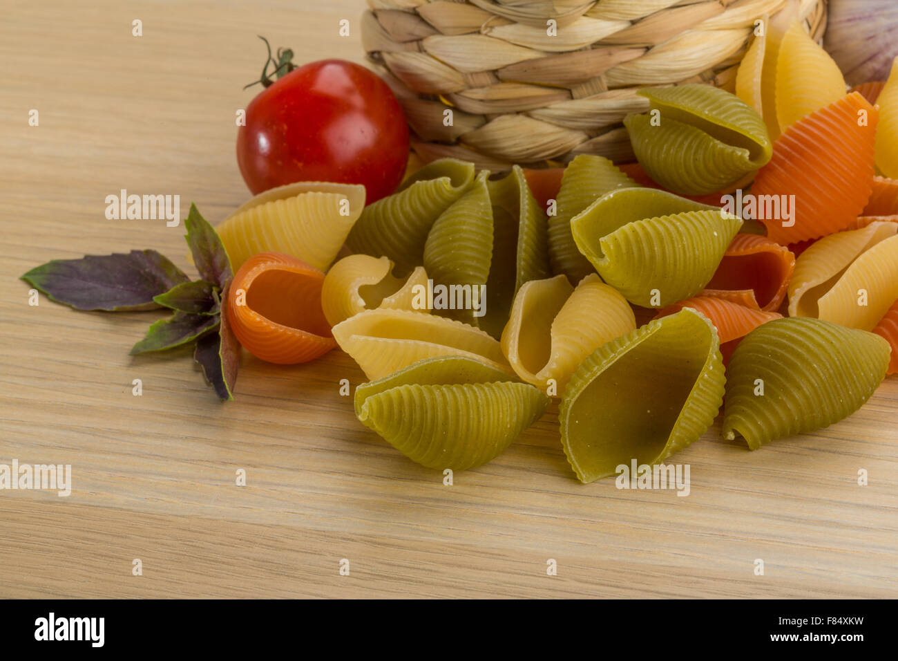 Raw macaroni - shell pasta with herbs Stock Photo - Alamy