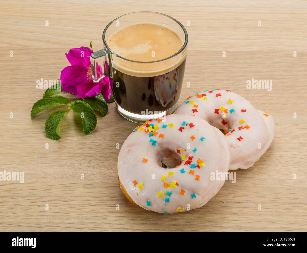Glazed donuts with coffee on the desk Stock Photo - Alamy