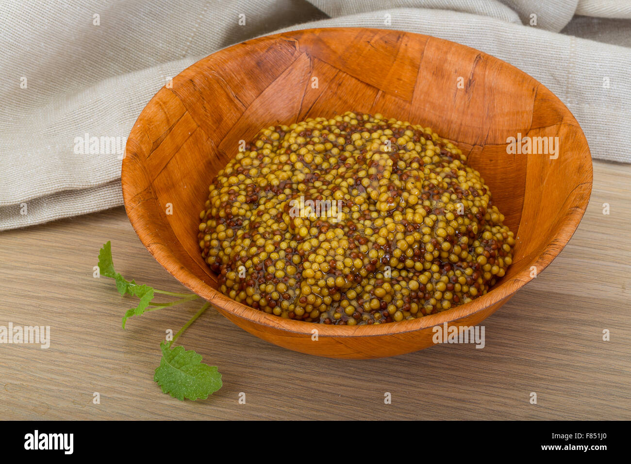 French mustard with fresh leaves on wooden background Stock Photo - Alamy