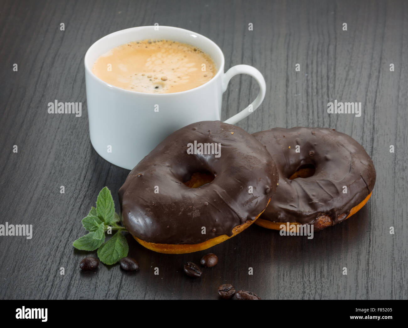 Chocolate donuts with coffee on the desk Stock Photo - Alamy