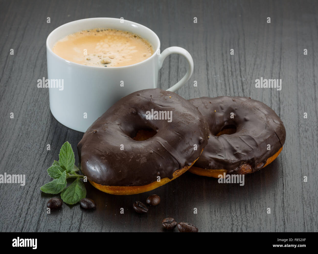 Chocolate donuts with coffee on the desk Stock Photo - Alamy
