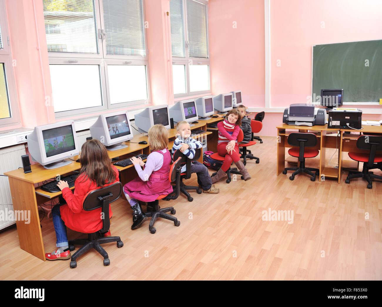 it education with children group in school at computer science class ...