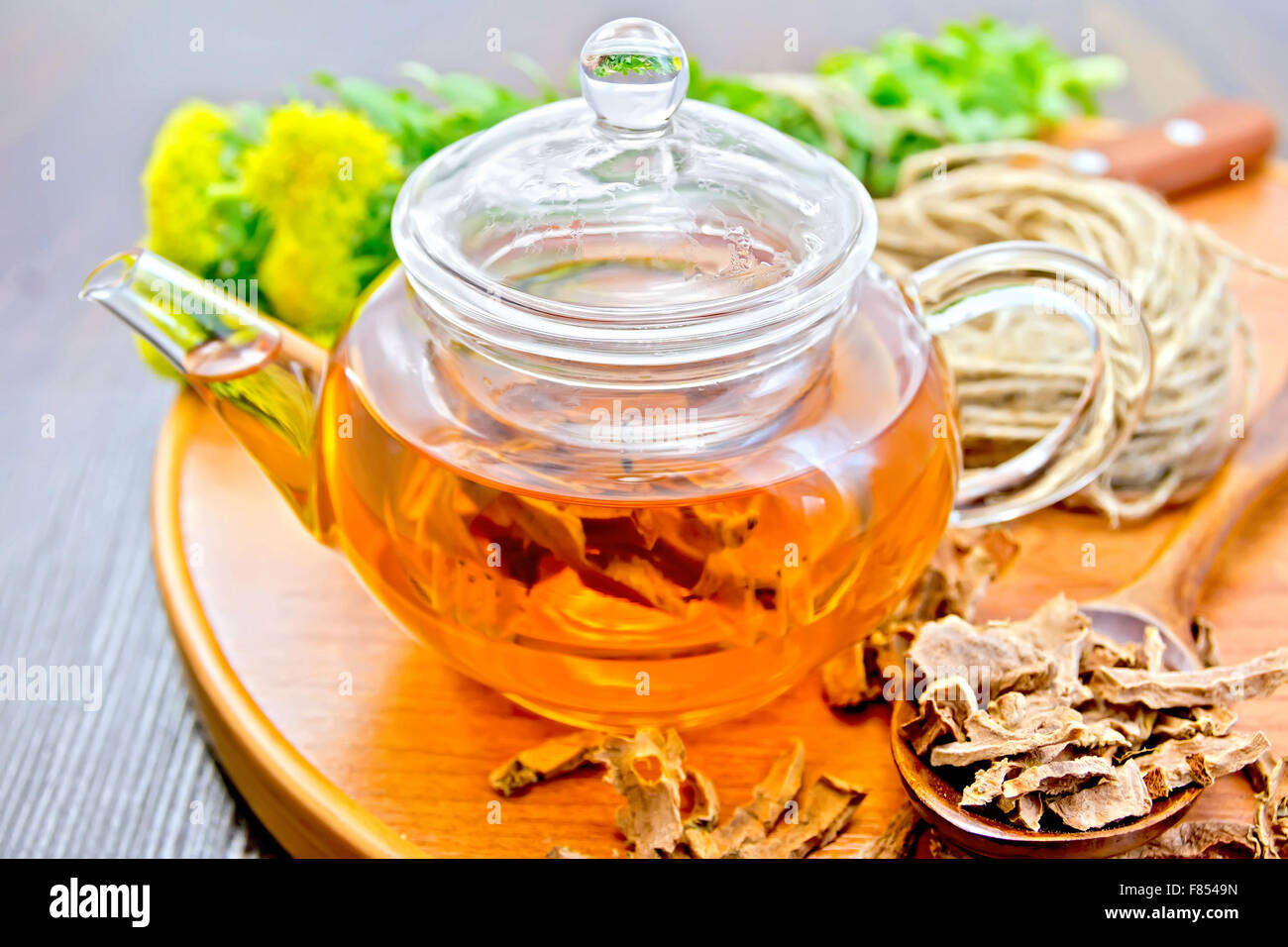 Tea of Rhodiola rosea in glass teapot on tray with spoon Stock Photo ...