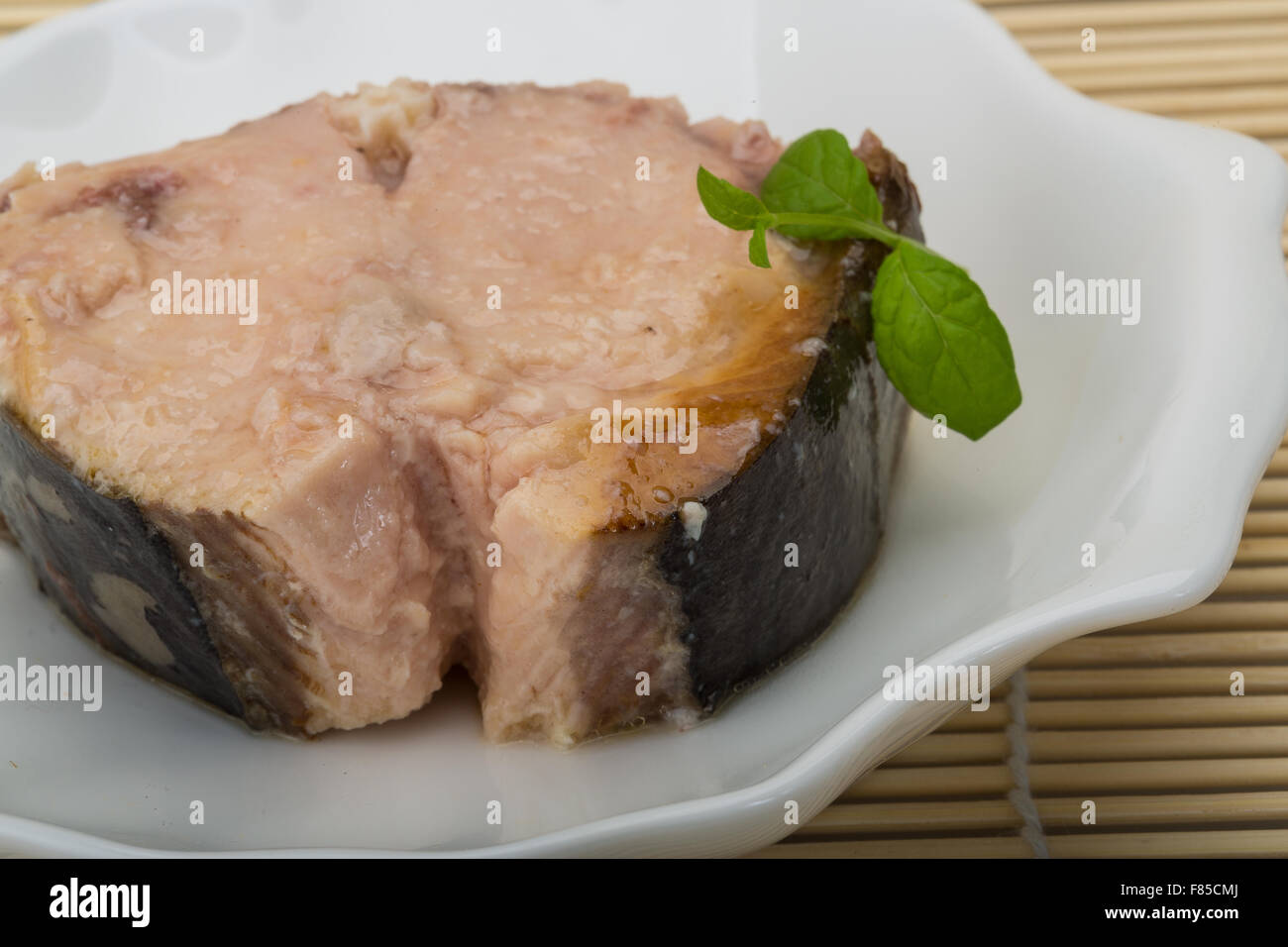 Canned tuna in the plate with green leaves Stock Photo - Alamy